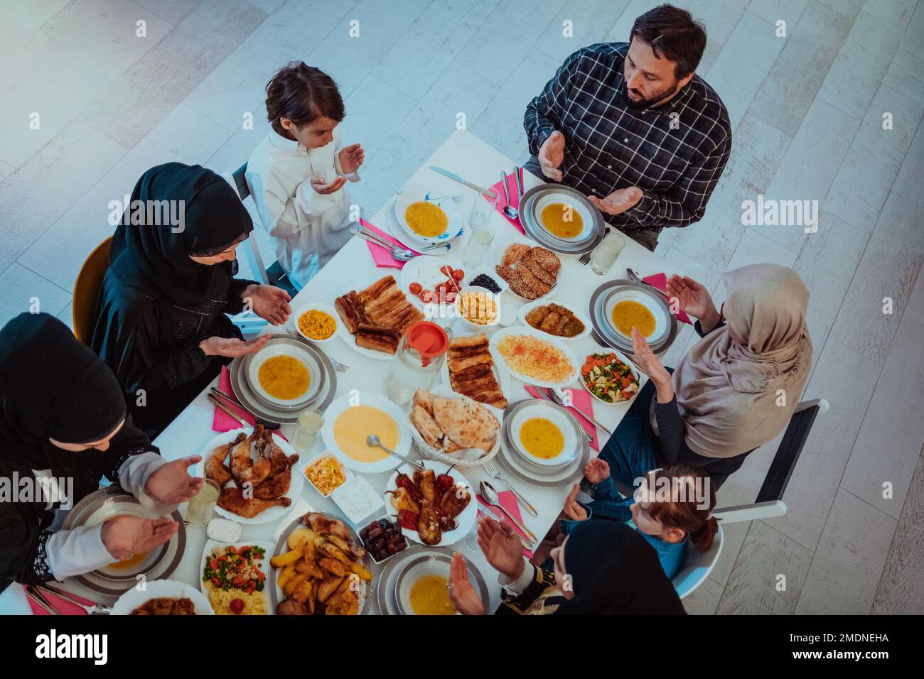 Top view of Muslim family having Iftar dinner drinking water to break ...