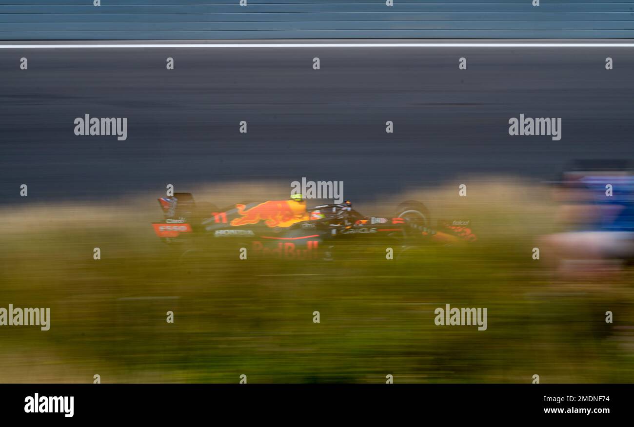 Red Bull driver Sergio Perez of Mexico steers his car through one of the banked corners during ...