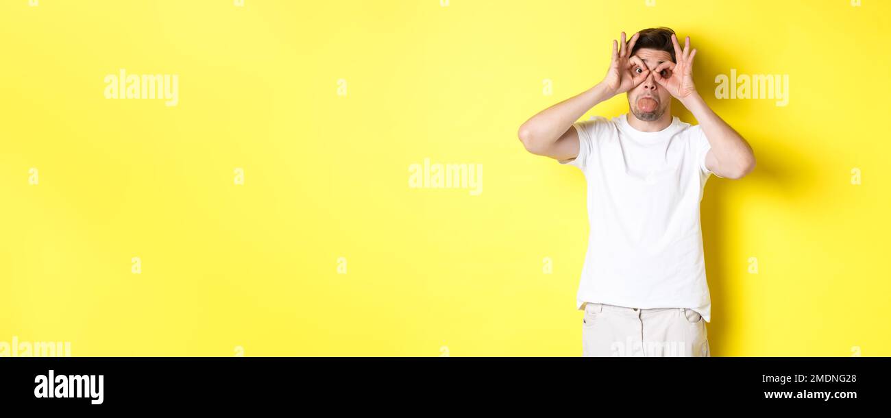 Young man making funny faces and showing tongue, fool around, standing ...