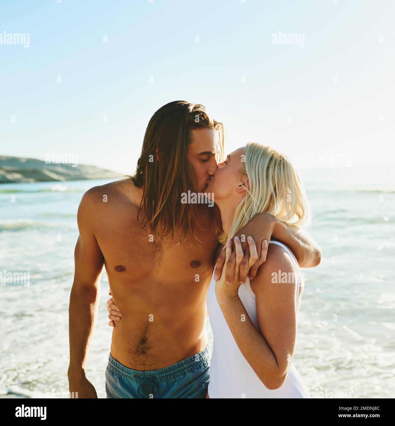 No words are needed, just love. an affectionate young couple kissing each other at the beach ...