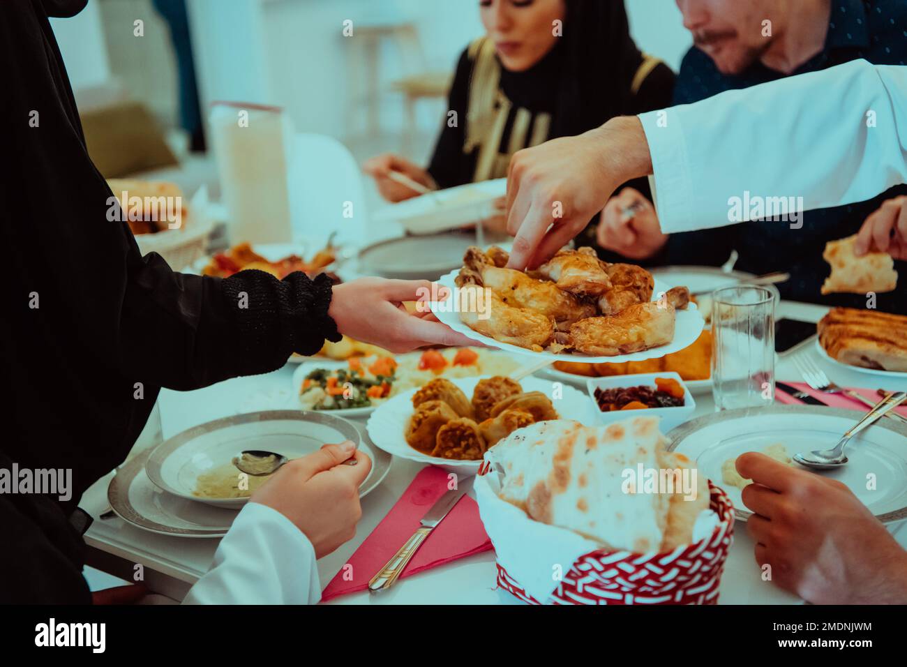 Muslim family having Iftar dinner drinking water to break feast. Eating ...