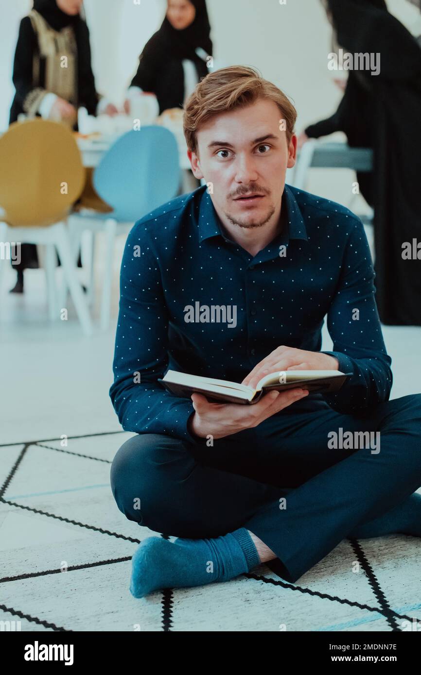 young muslim man sitting on the floor while reading holy book Quran ...