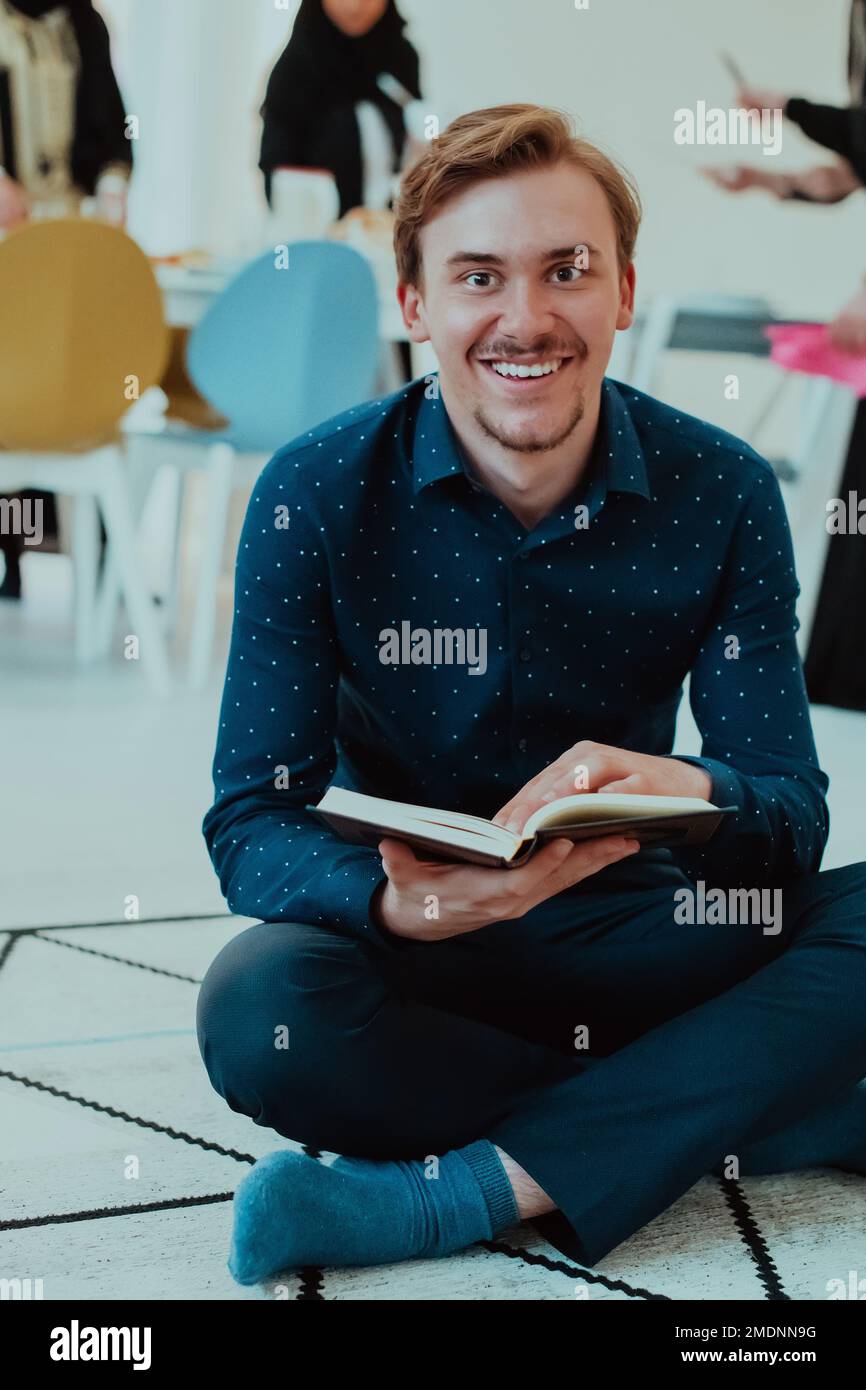 young muslim man sitting on the floor while reading holy book Quran ...