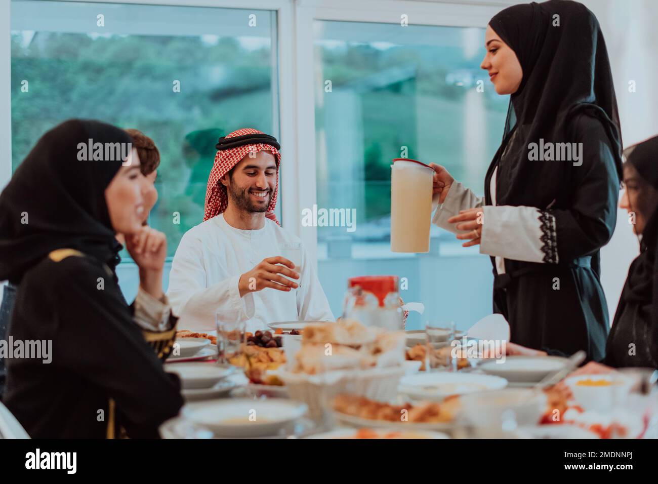 Muslim family having Iftar dinner drinking water to break feast. Eating ...