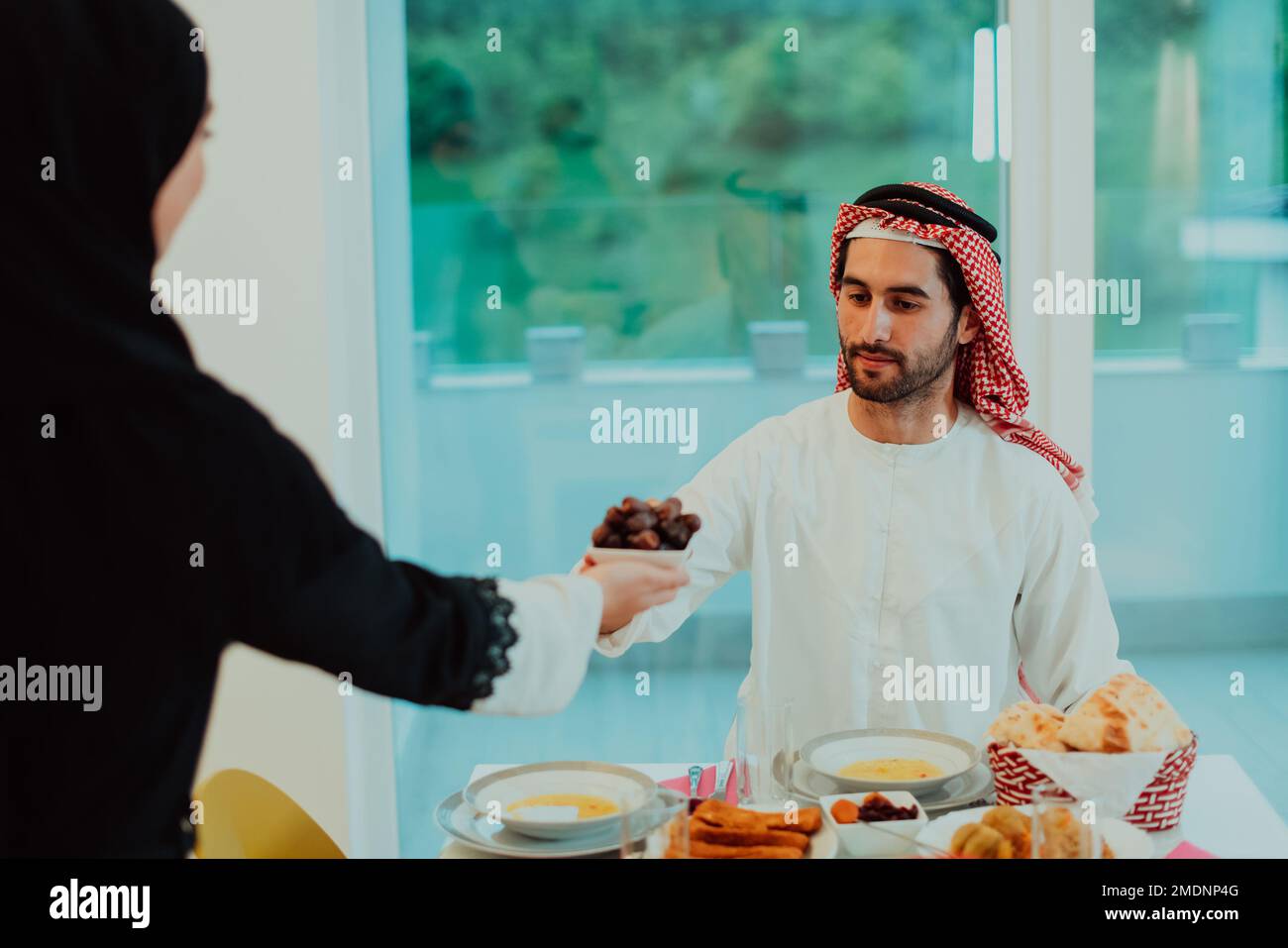 Modern multiethnic muslim family sharing a bowl of dates while enjoying ...