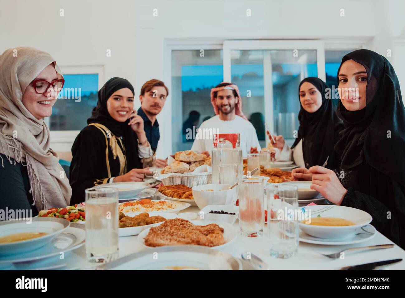 Muslim family having Iftar dinner drinking water to break feast. Eating ...