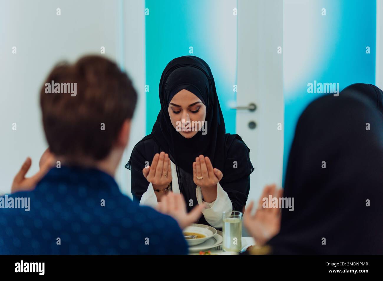 A Muslim family praying together, the Muslim prayer after breaking the ...