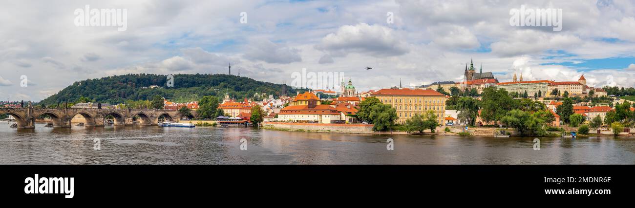 waterfront view across the river Vltava to Castle, Charles Bridge and Petrin Lookout tower ...