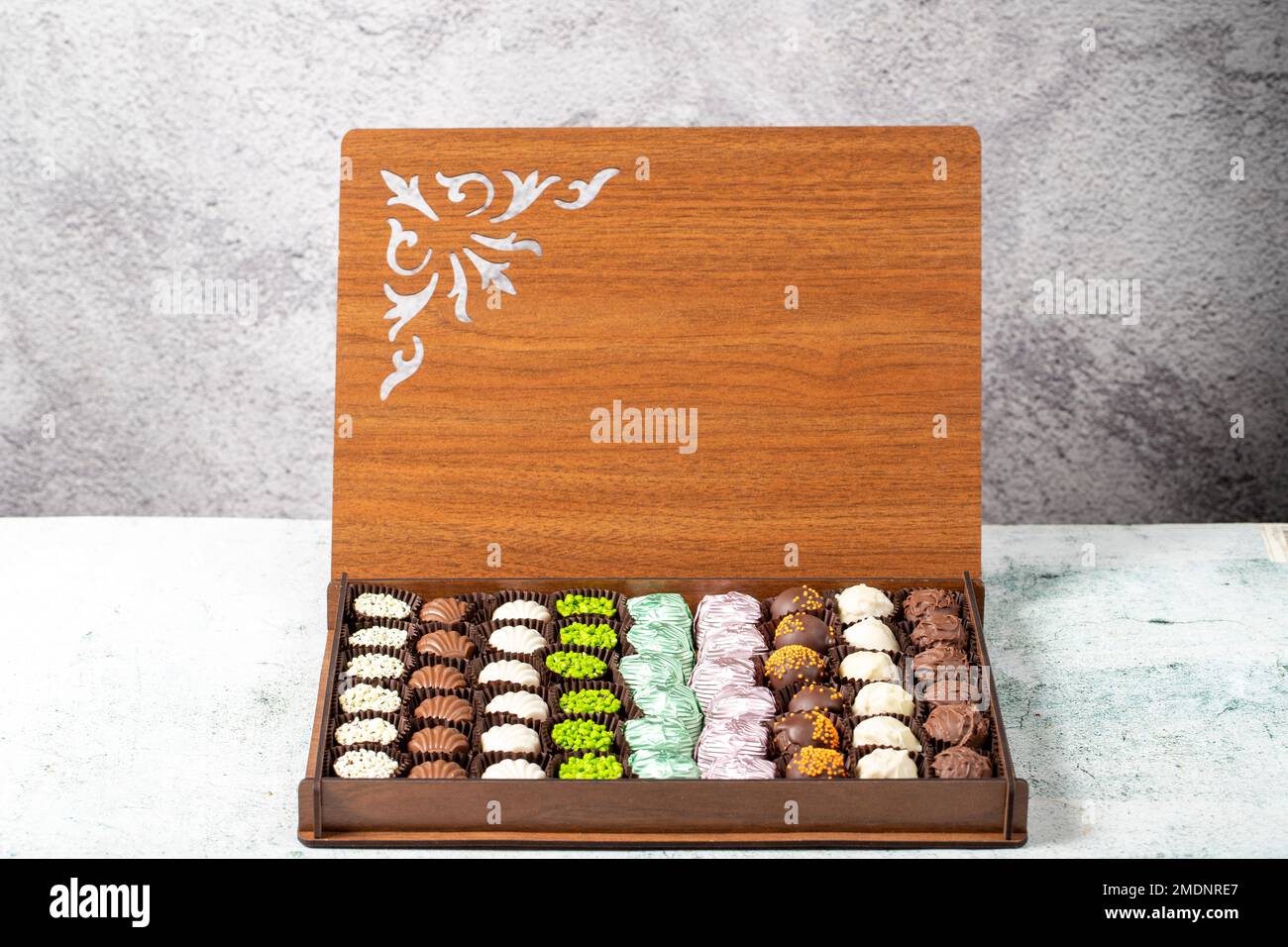 Box with delicious chocolate candies. Truffle chocolate on gray ...