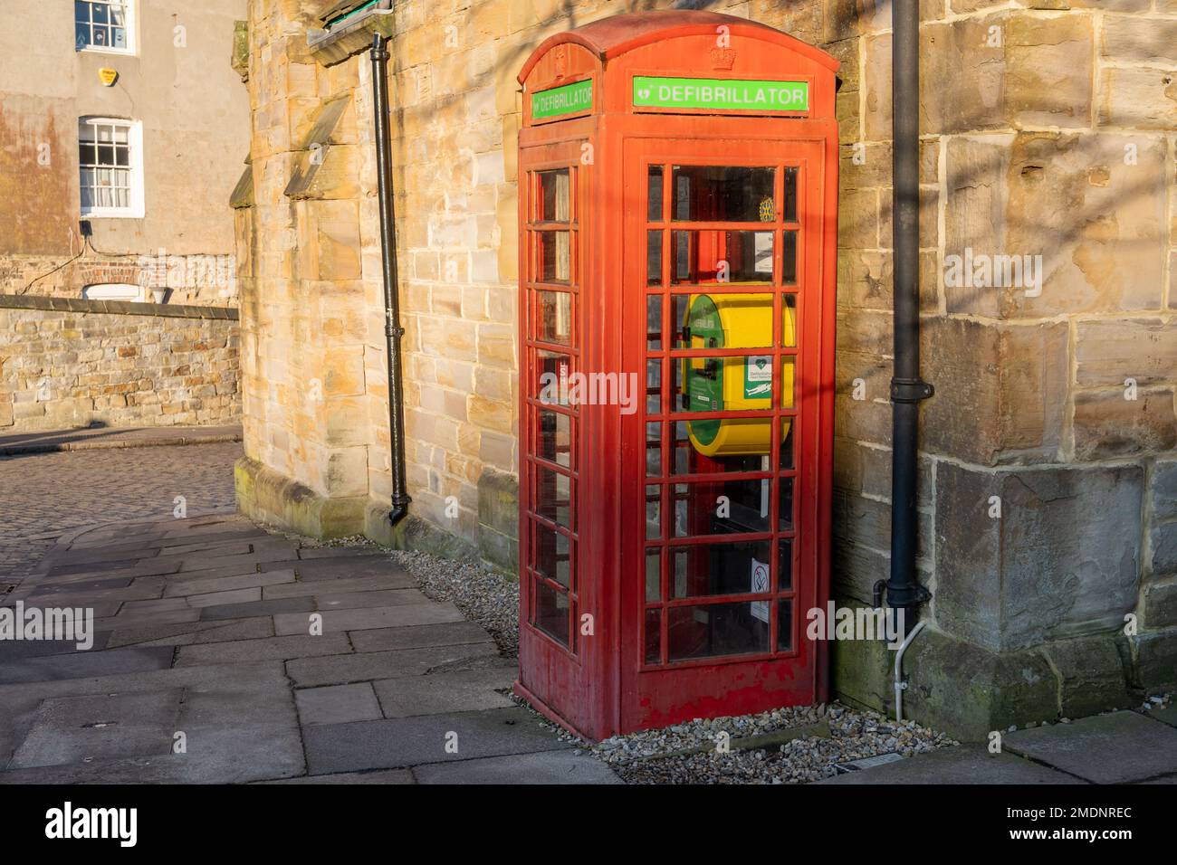 A vintage red telephone box at Palace Green, Durham, UK, converted to ...