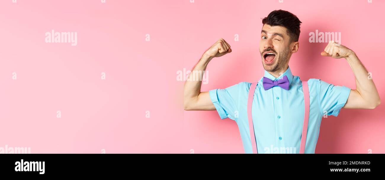Strong and funny guy with french moustache, flexing biceps and winking ...