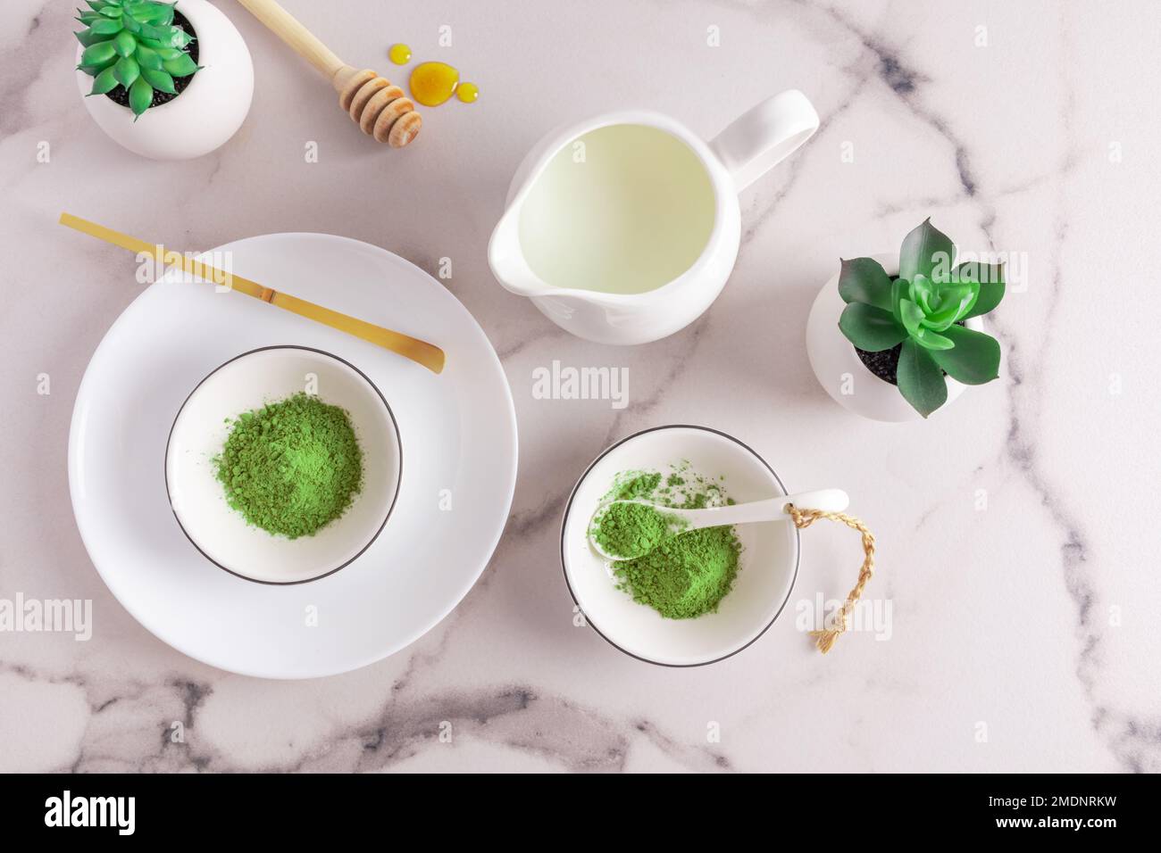 matcha tea powder in white ceramic bowls and a special bamboo measuring ...