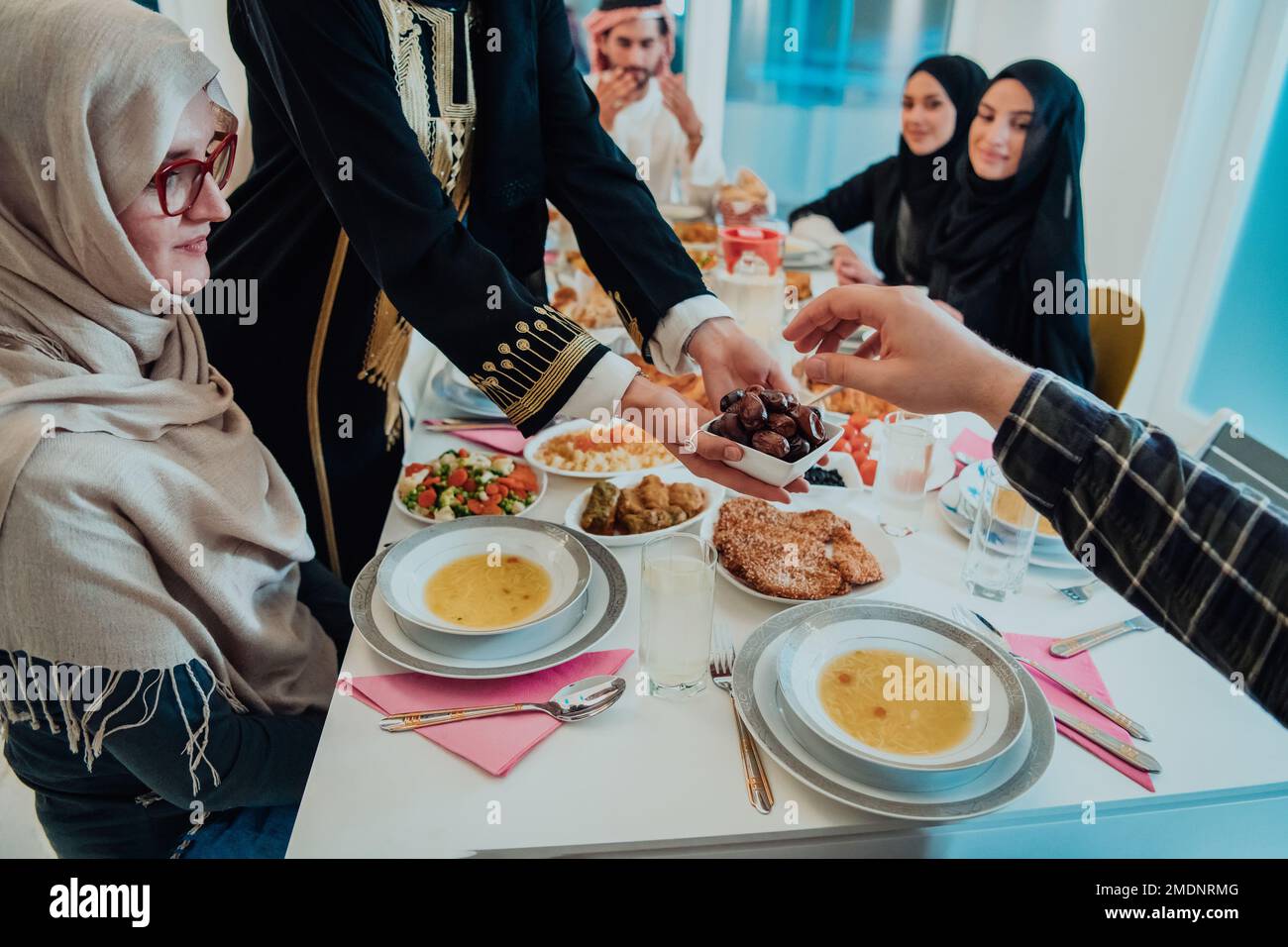 Muslim family having Iftar dinner drinking water to break feast. Eating ...