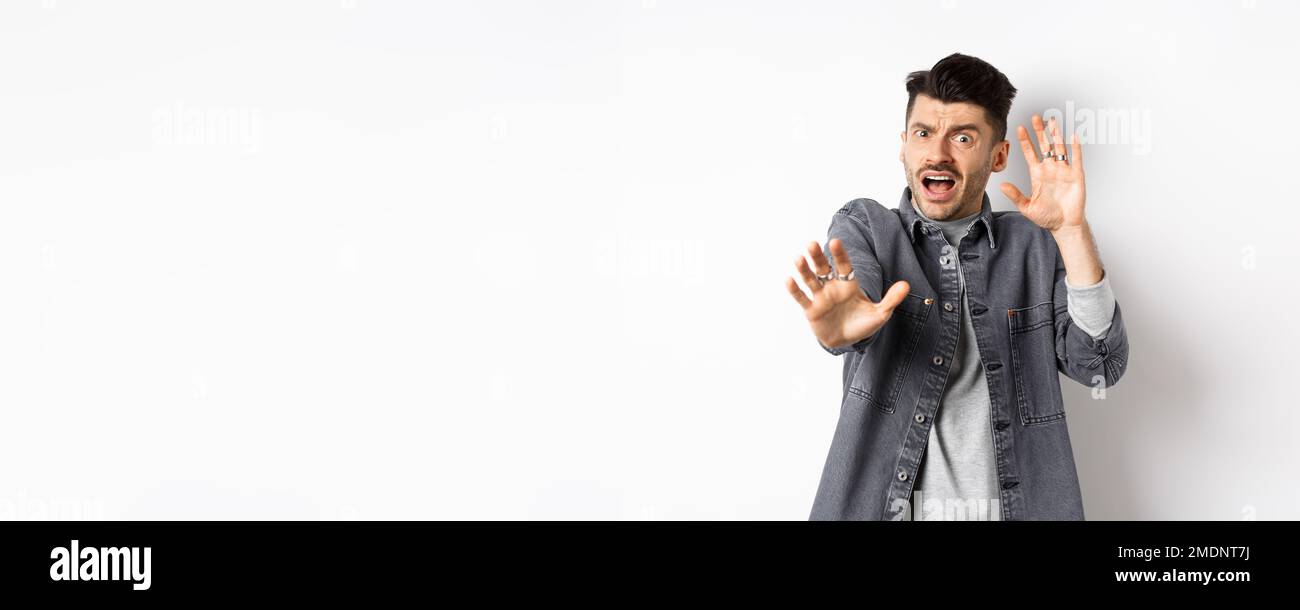 Scared timid guy screaming and raising hands in pleading pose, begging ...