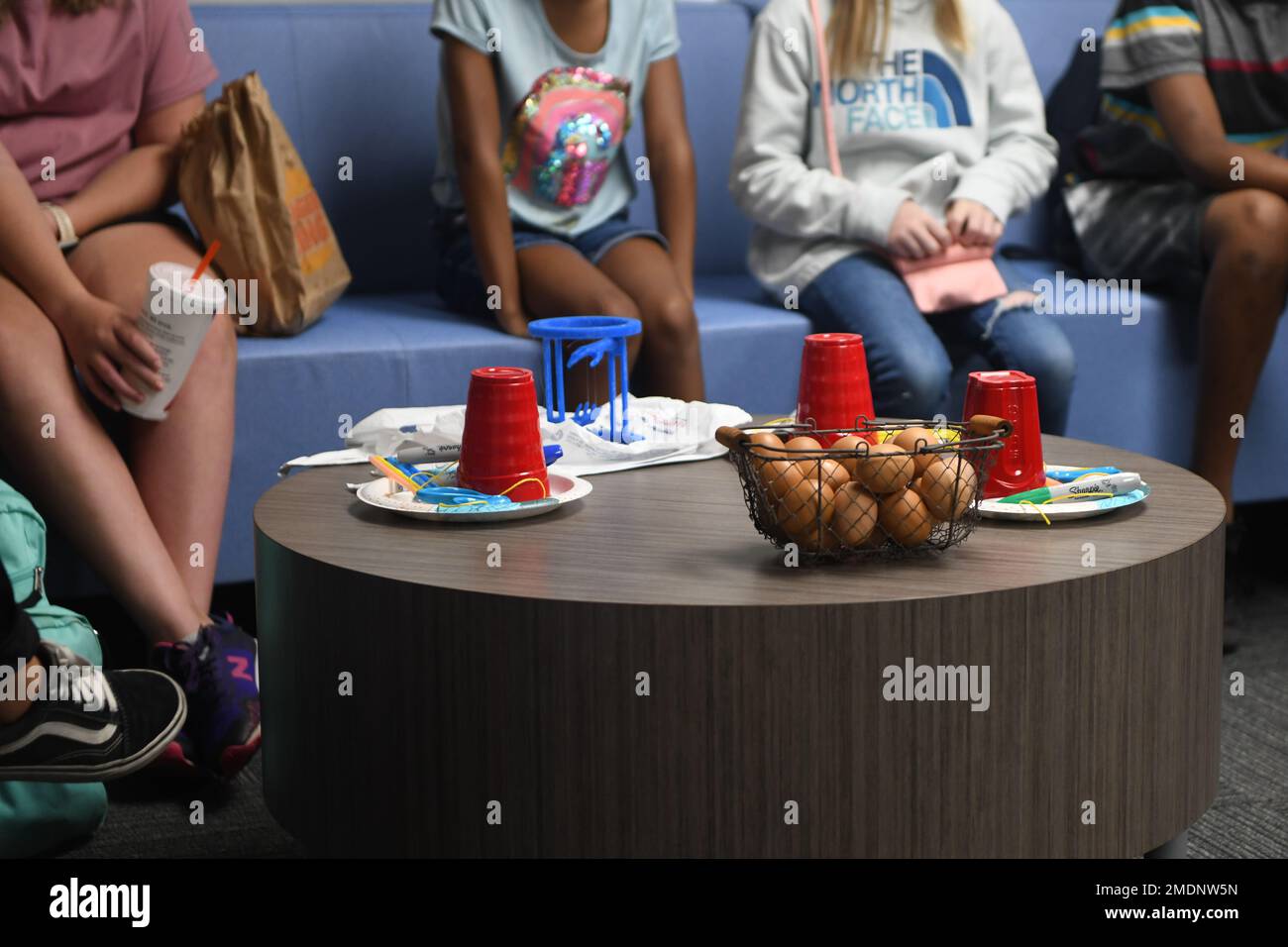 Materials for an egg-drop competition lay out in front of students at ...