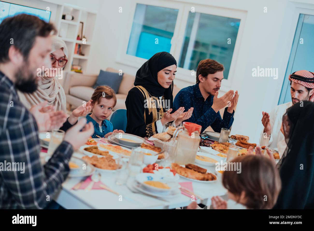 A Muslim family praying together, the Muslim prayer after breaking the ...