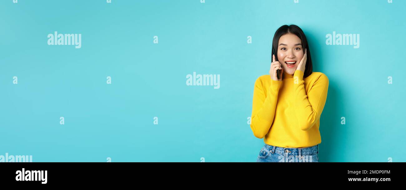 Happy asian woman receive offer on phone call, smiling while talking on ...