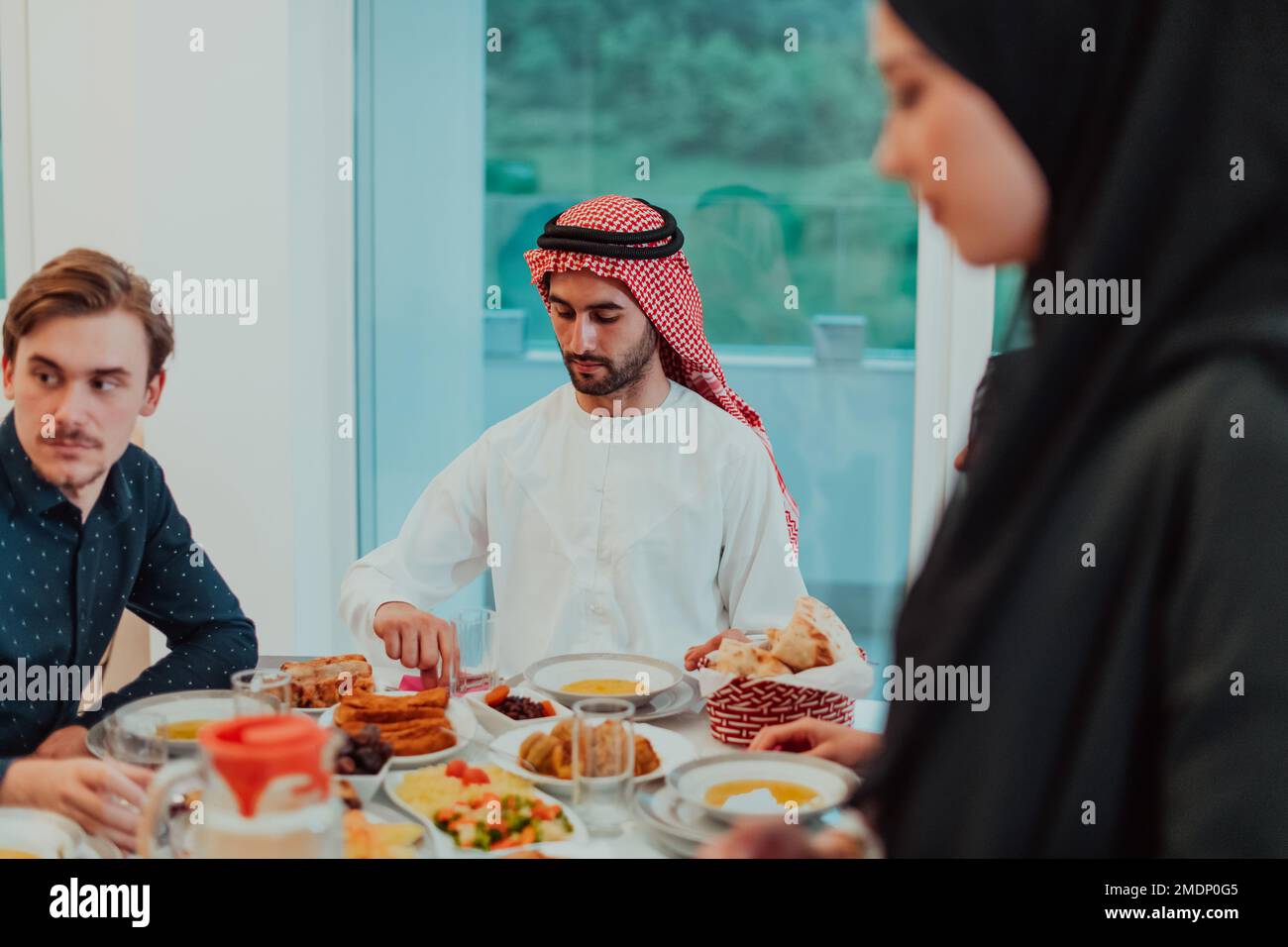 Muslim family having Iftar dinner drinking water to break feast. Eating ...