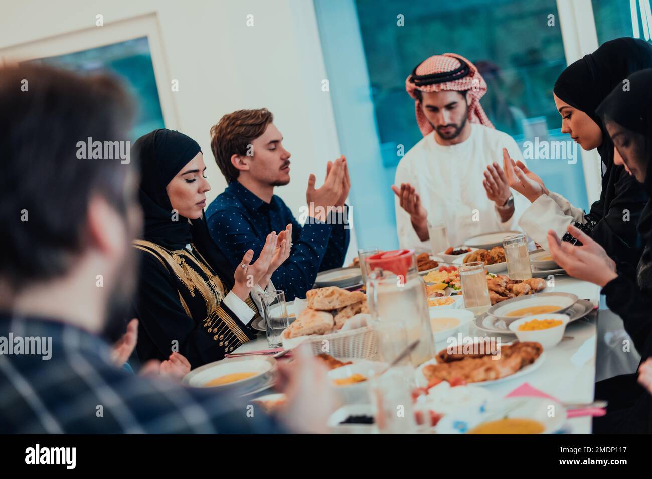 A Muslim family praying together, the Muslim prayer after breaking the ...