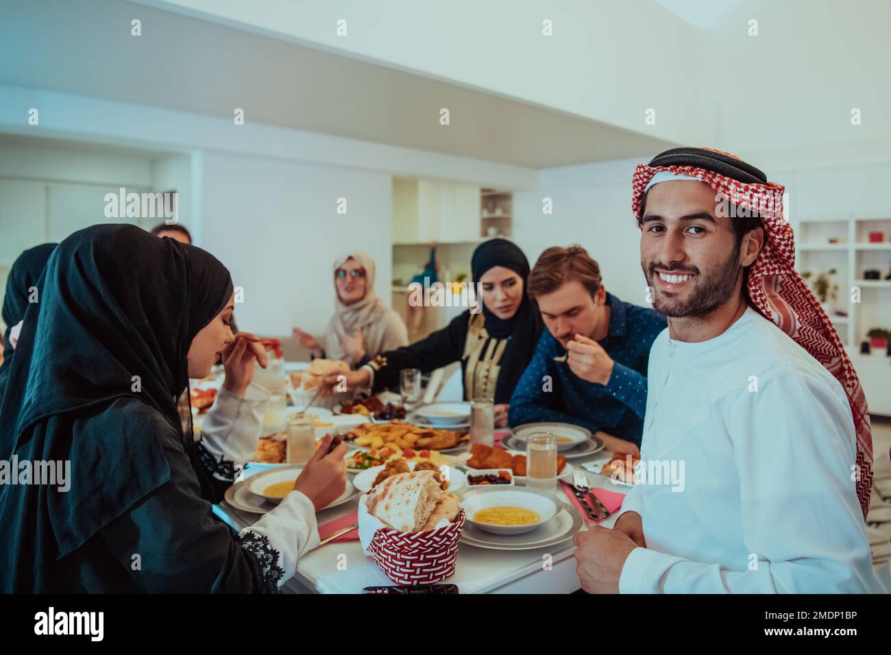 Muslim family having Iftar dinner drinking water to break feast. Eating ...