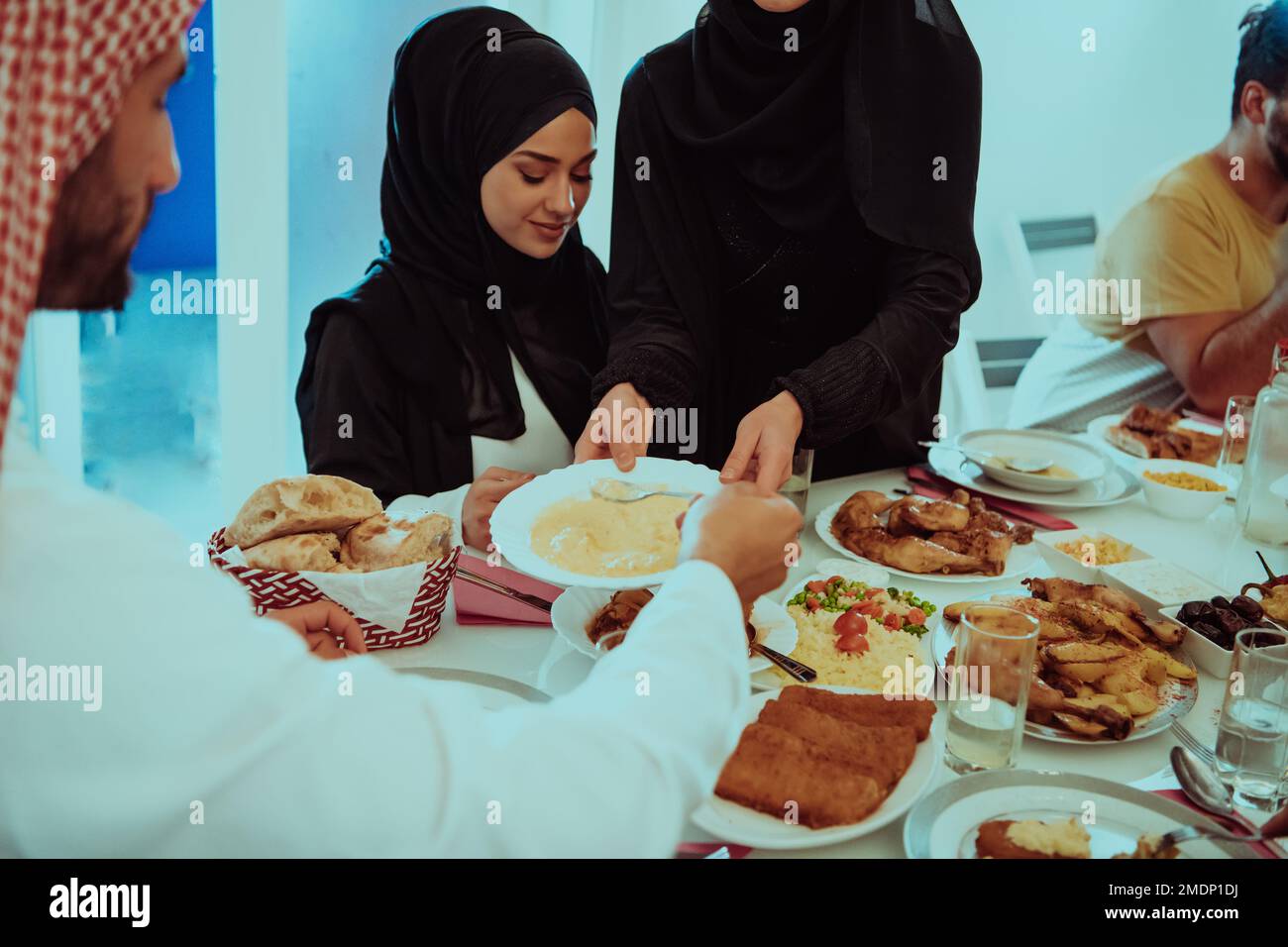 Muslim family having Iftar dinner drinking water to break feast. Eating ...