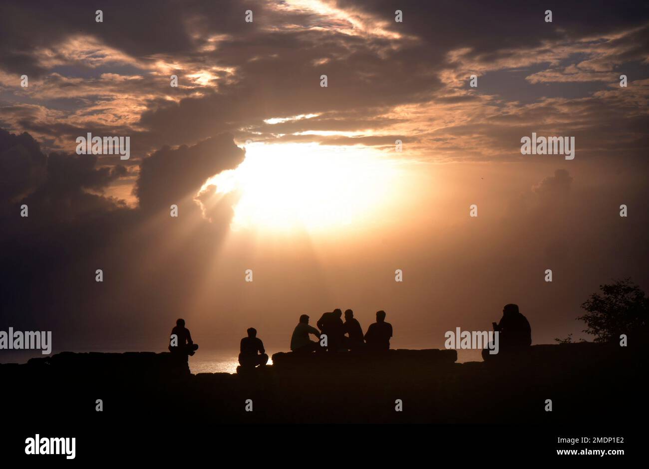 People watch the sunset from the ramparts of the 17th century Chapora ...