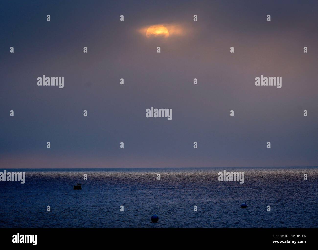 The rising sun is seen between clouds and fog over the Baltic Sea in ...