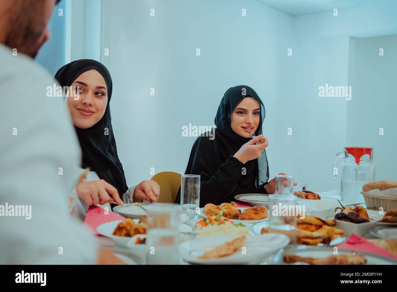 Muslim family having Iftar dinner drinking water to break feast. Eating ...
