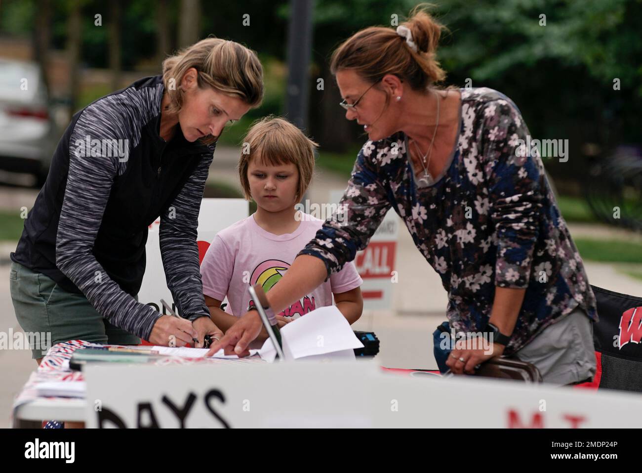 Kimberly Klimek with her daughter Lily sign a petition to recall the ...