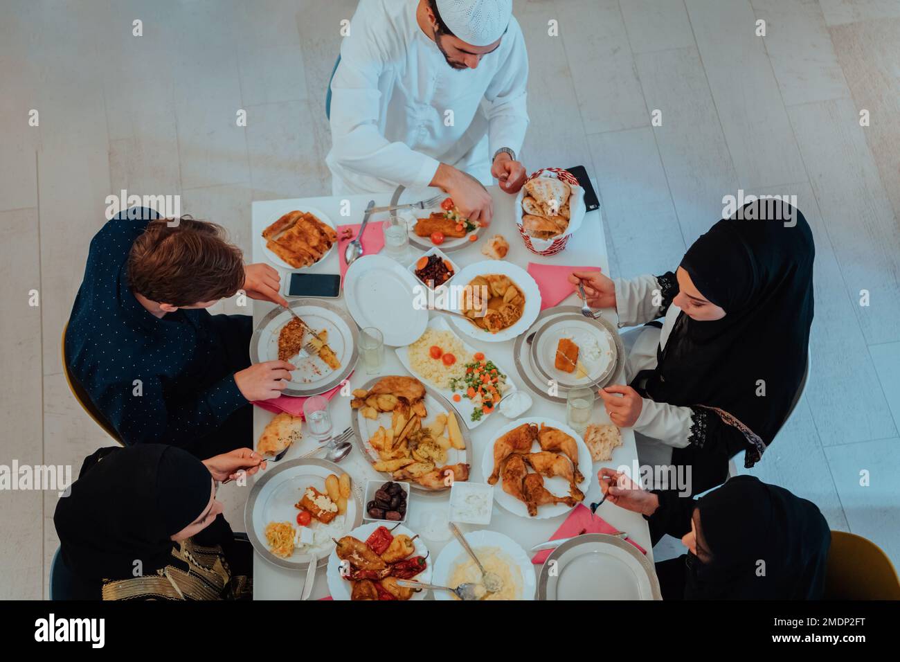 Top view of Muslim family having Iftar dinner drinking water to break ...