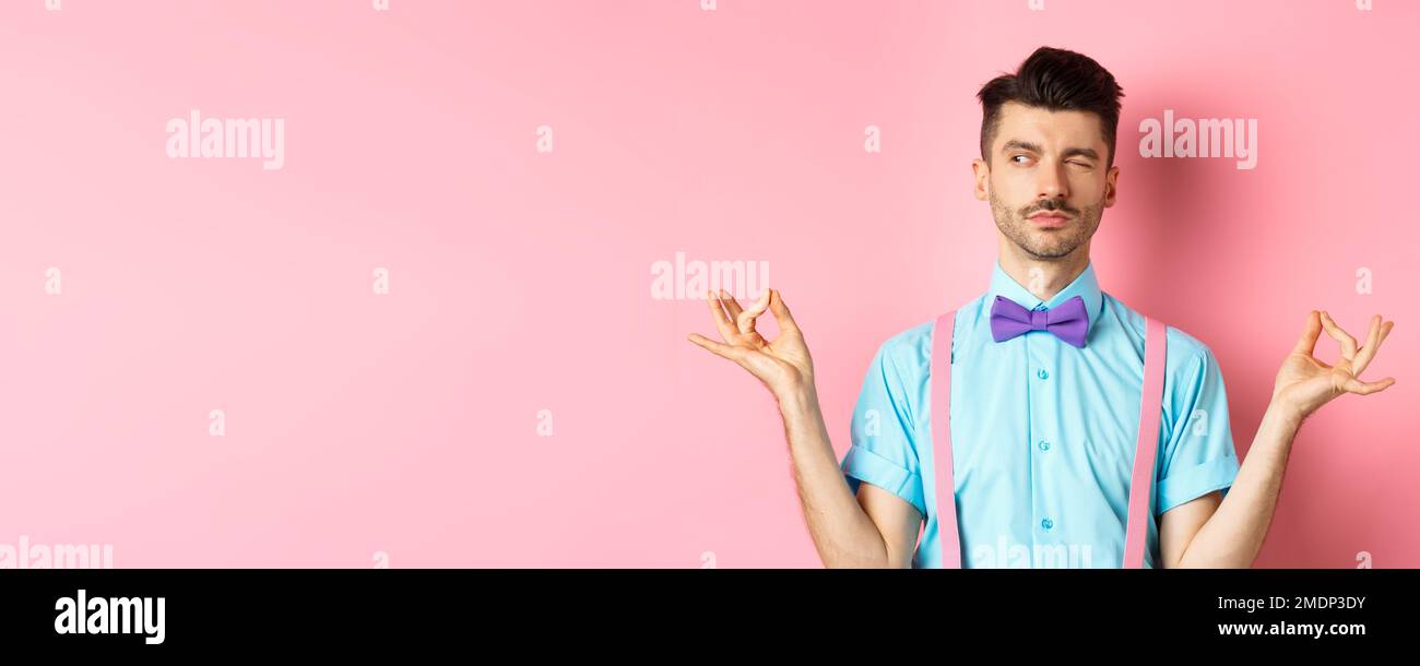 Funny guy with moustache and bow-tie fake meditating, peeking aside ...