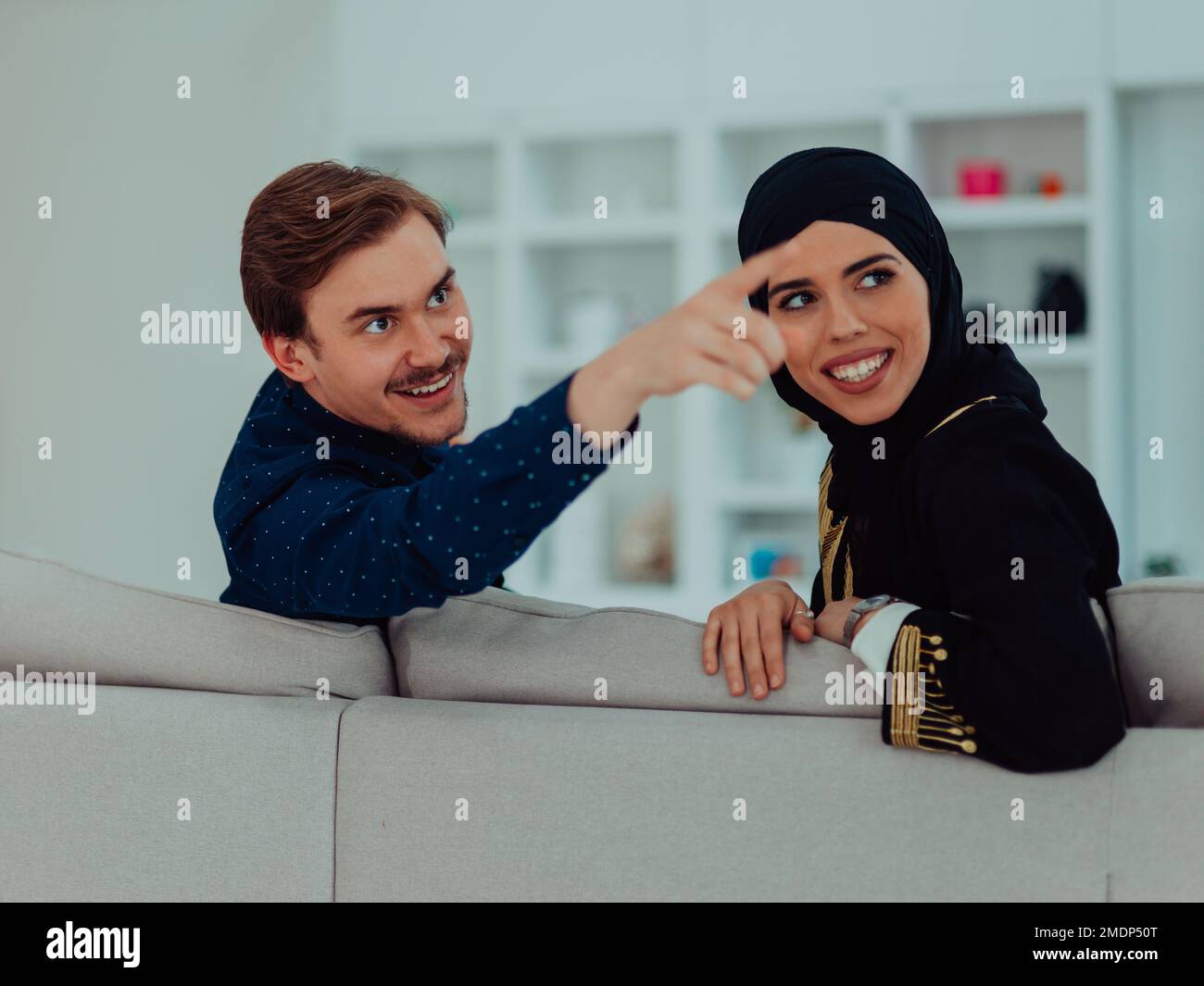 Young muslim couple woman wearing islamic hijab clothes sitting on sofa ...