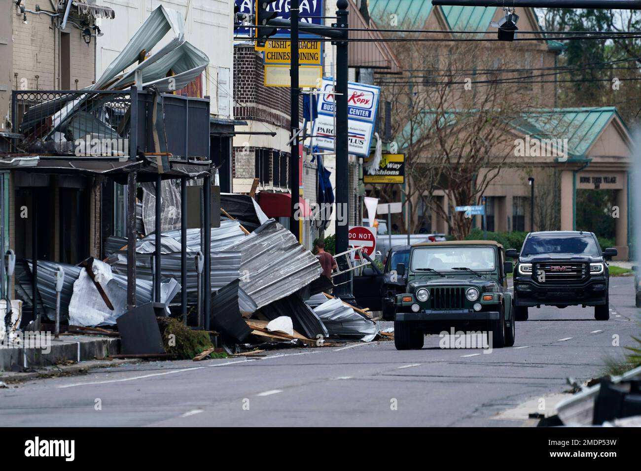Traffic passes by piles of debris on the sidewalk of Main Street in ...