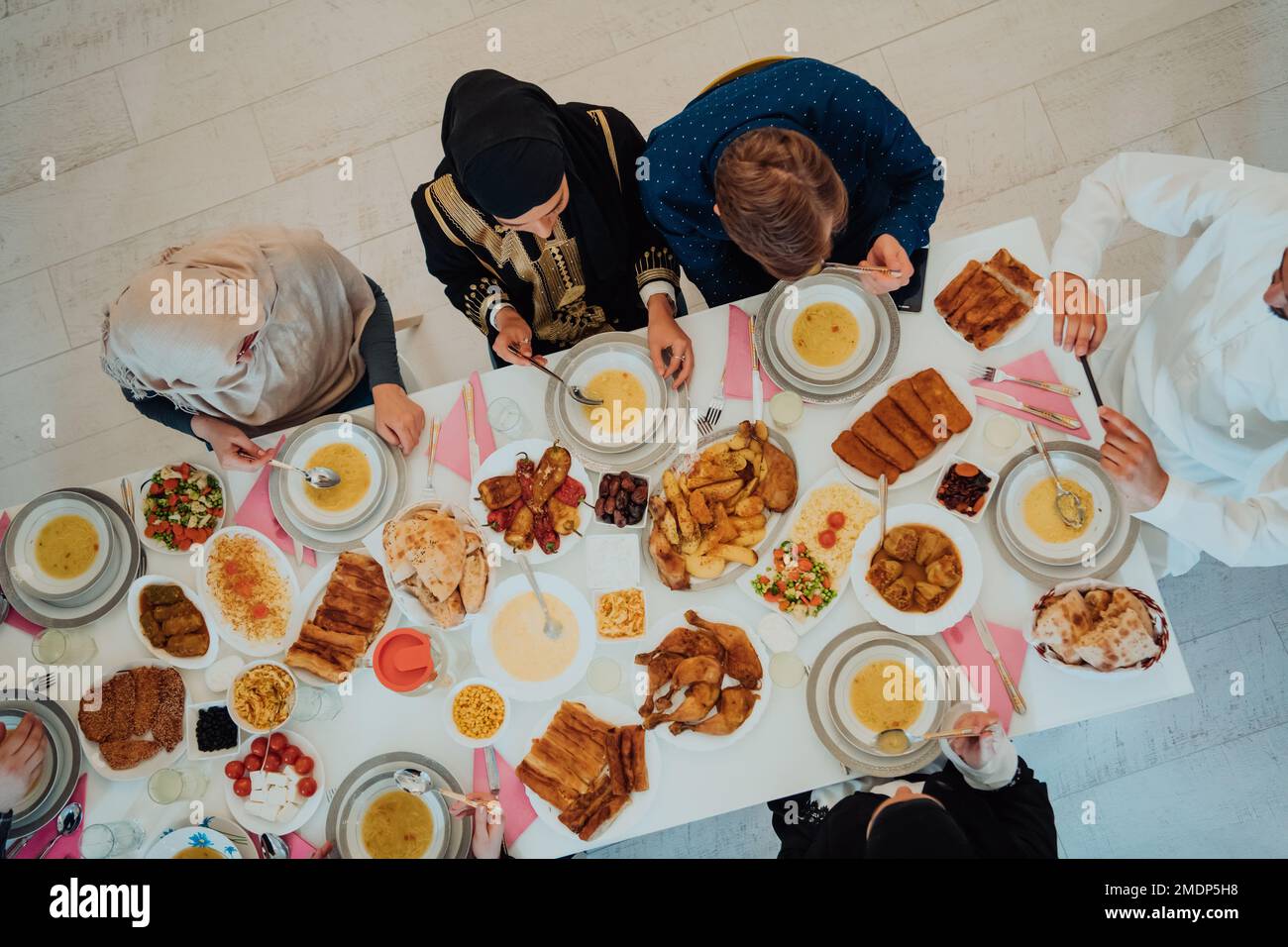 Top view of Muslim family having Iftar dinner drinking water to break ...