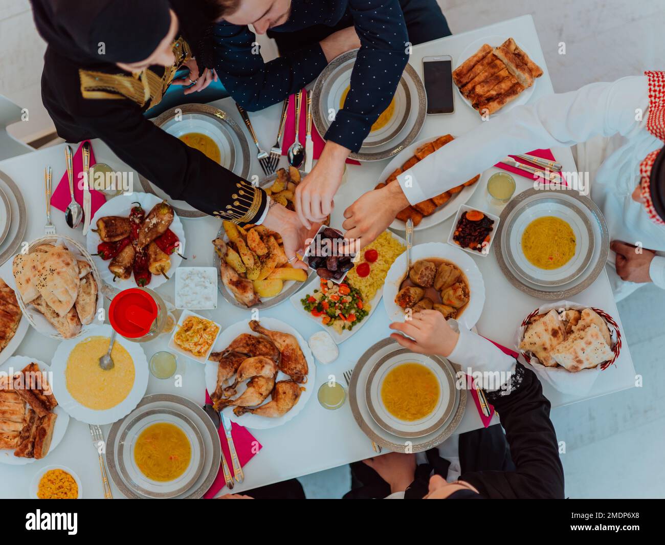 Top view of Muslim family having Iftar dinner drinking water to break ...