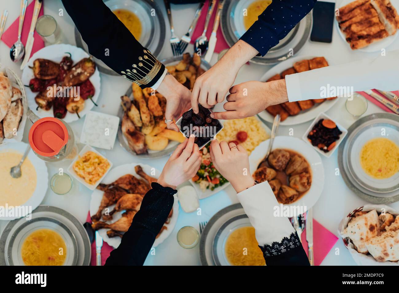 Muslim family having Iftar dinner drinking water to break feast. Eating ...