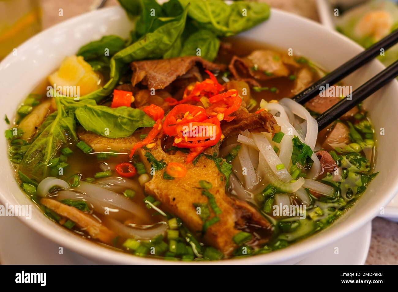 Pho Bo or Vietnamese Soup with beef and meat balls served in a white ...