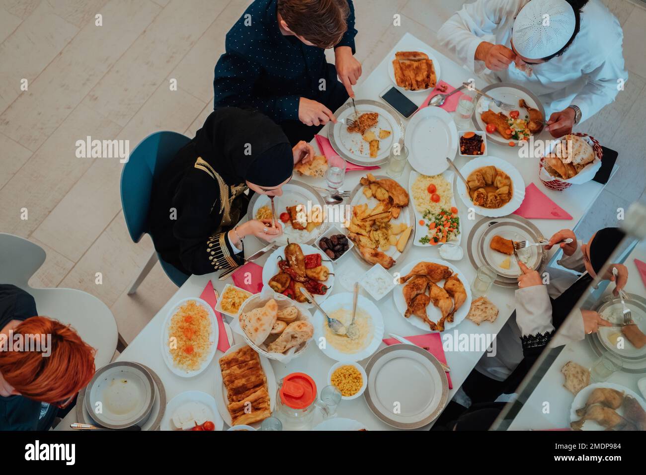 Top view of Muslim family having Iftar dinner drinking water to break ...