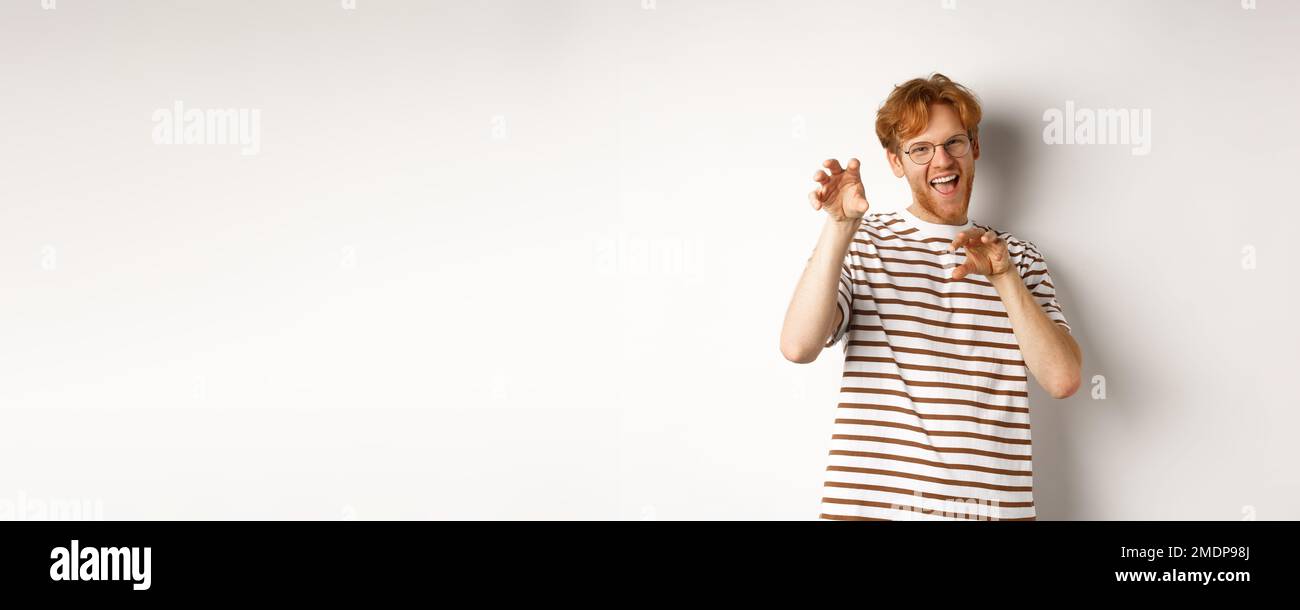Funny young man with red hair and beard showing claws gesture and ...