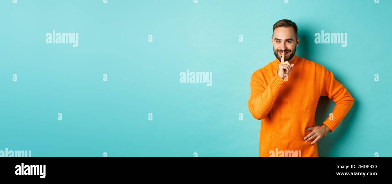 Happy man asking keep voice down, shushing and smiling, prepare ...