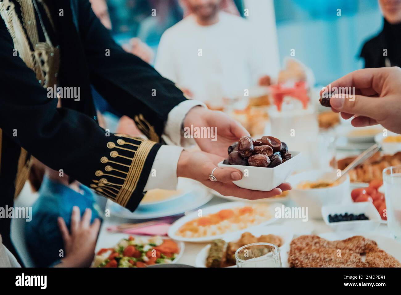 Muslim family having Iftar dinner drinking water to break feast. Eating ...