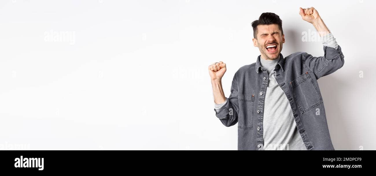Sweet taste of success. Happy pleased young man screaming yes, making ...