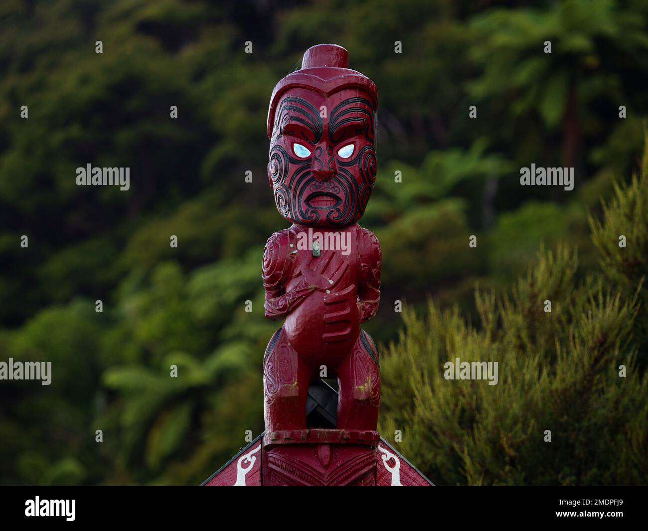 Traditional ancient red wooden Maori sculpture figure in Abel Tasman ...