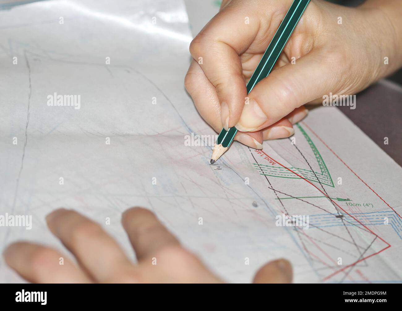 The woman hands tracing the sewing drawing Stock Photo - Alamy