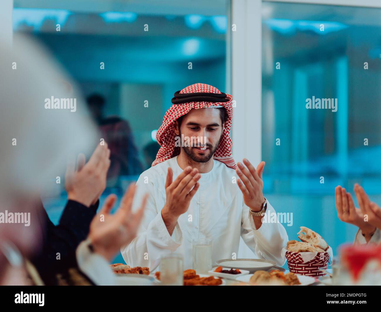 A Muslim family praying together, the Muslim prayer after breaking the ...
