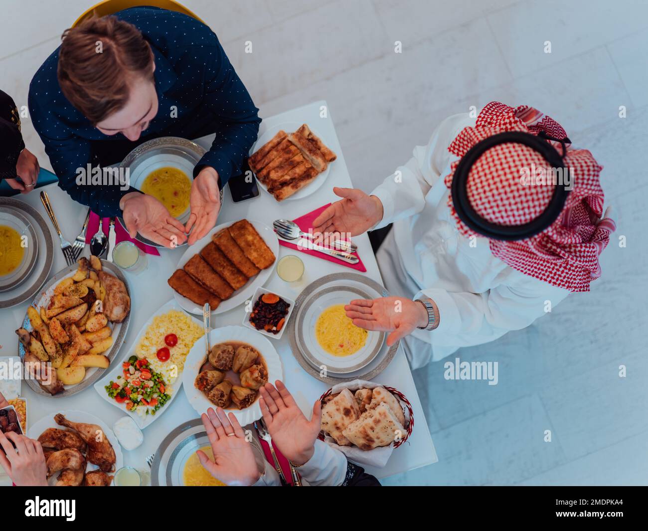 Top view of Muslim family having Iftar dinner drinking water to break ...