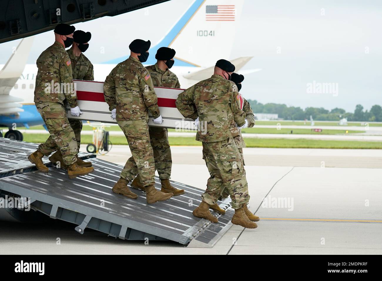 A carry team moves a transfer case containing the remains of Army Staff ...