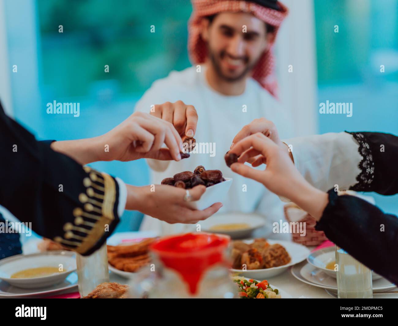 Modern multiethnic muslim family sharing a bowl of dates while enjoying ...