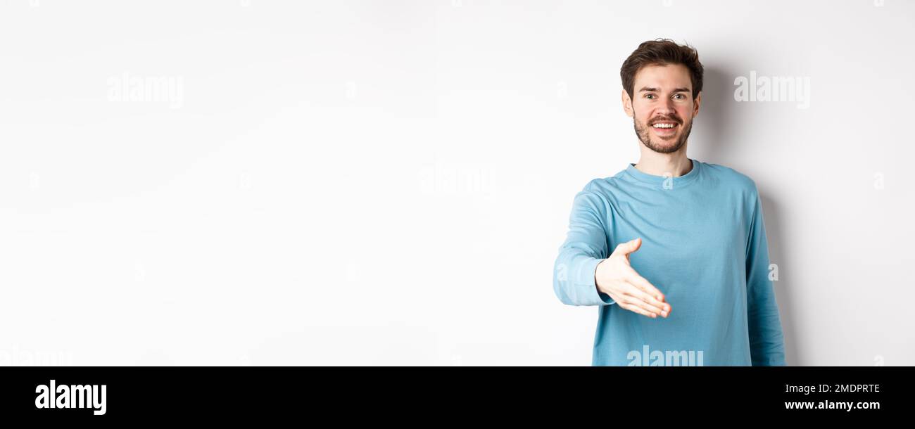 Friendly smiling man stretch out hand, saying hello and give arm for ...