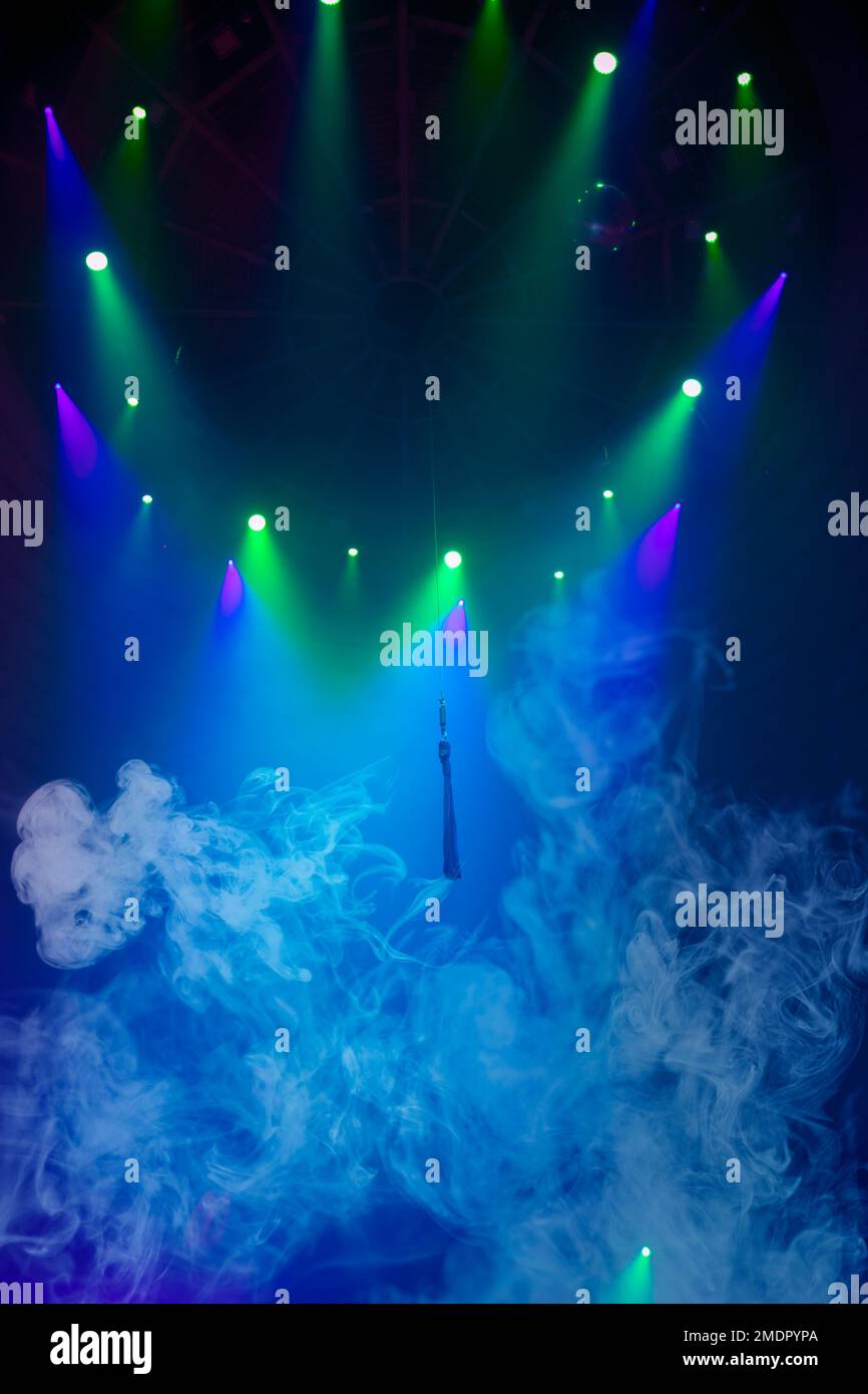 Blue stage circus smoke and green beams from projectors on a blue ...